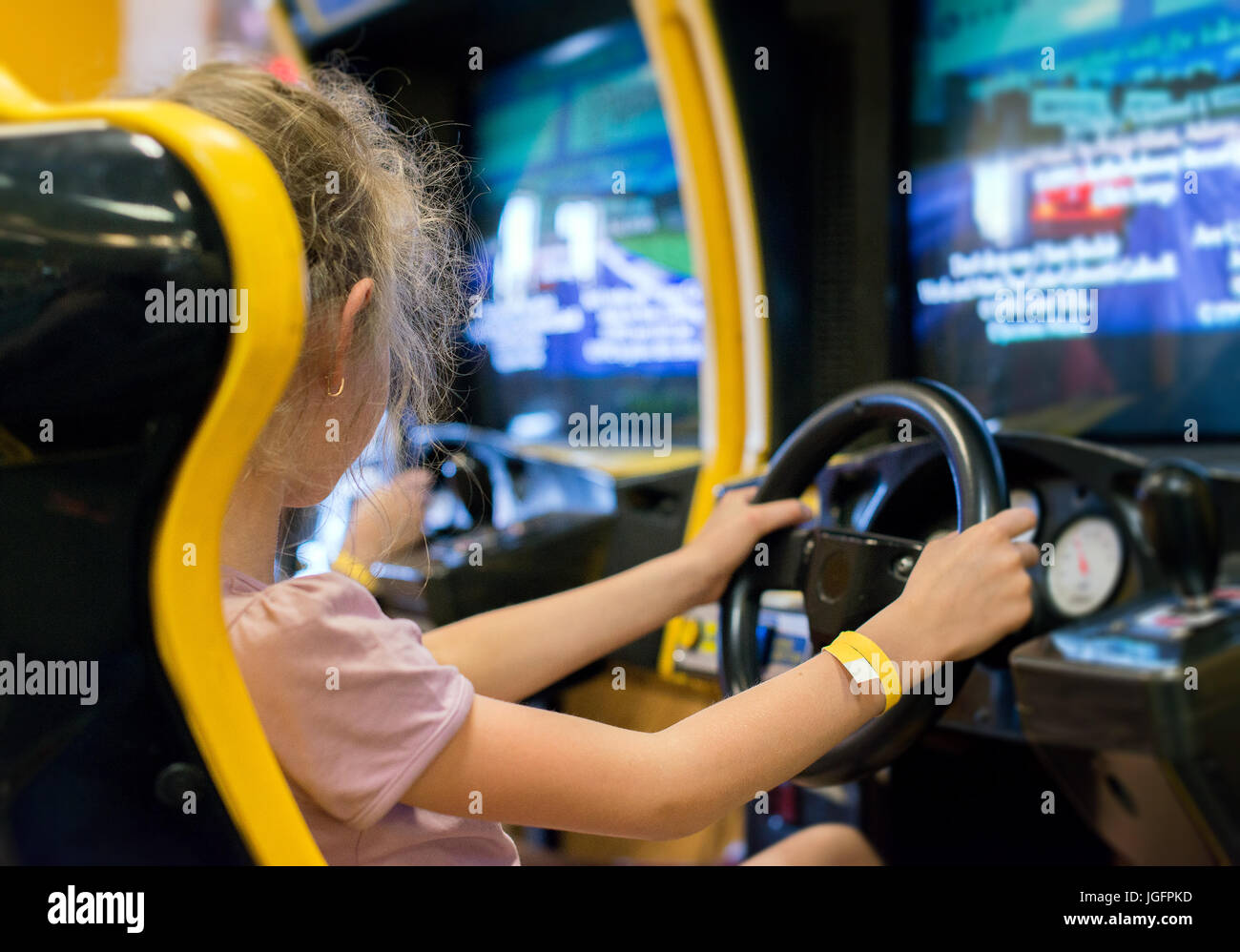 Little girl playing racing simulator game in theme park Stock Photo - Alamy
