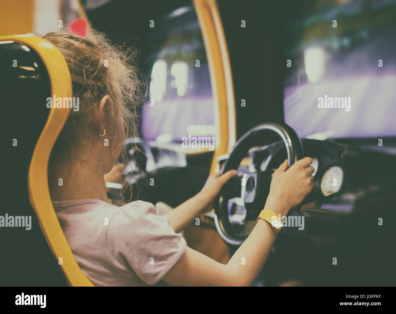 Little girl playing racing simulator game in theme park Stock Photo - Alamy