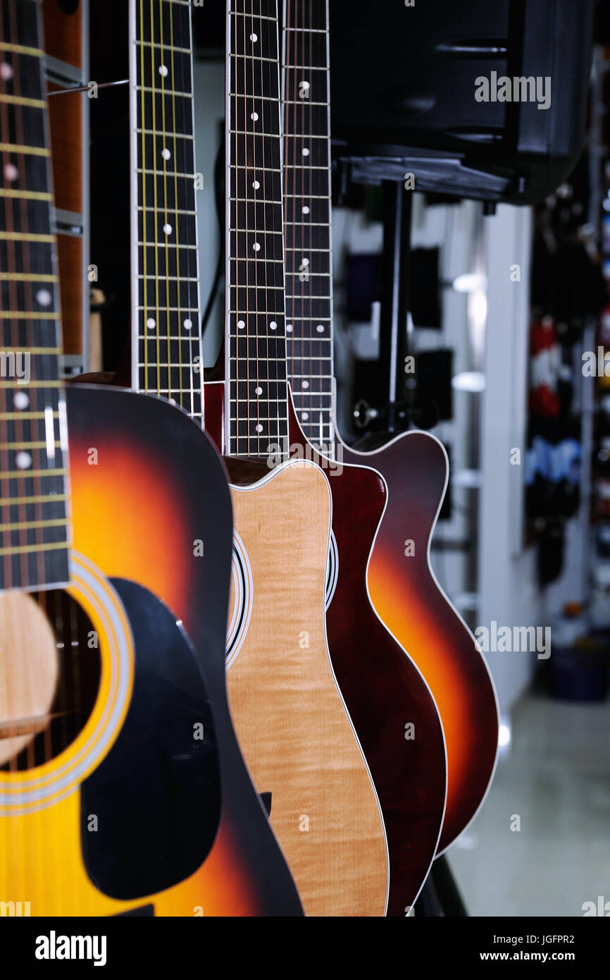 Colorful acoustic guitars in the store background Stock Photo - Alamy
