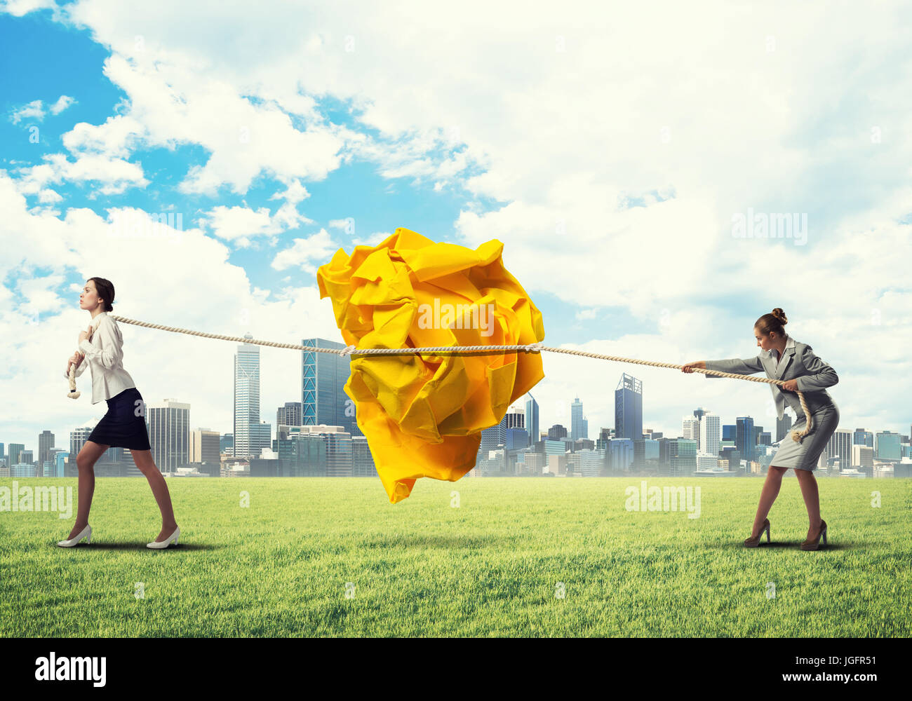 Two women pulling with effort big crumpled ball of paper as creativity ...