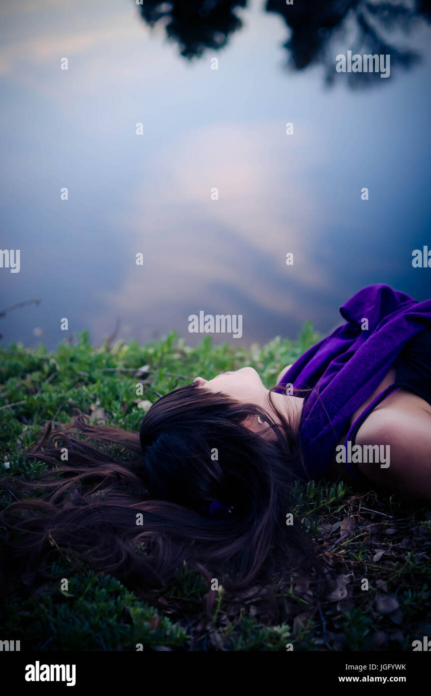 Girl sleeping next to a lake Stock Photo - Alamy