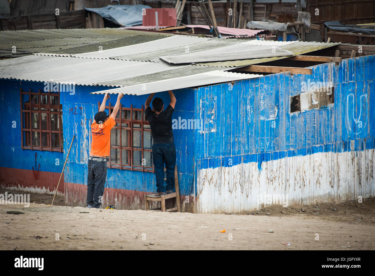 2 men building a makeshift roof in Peru Stock Photo - Alamy