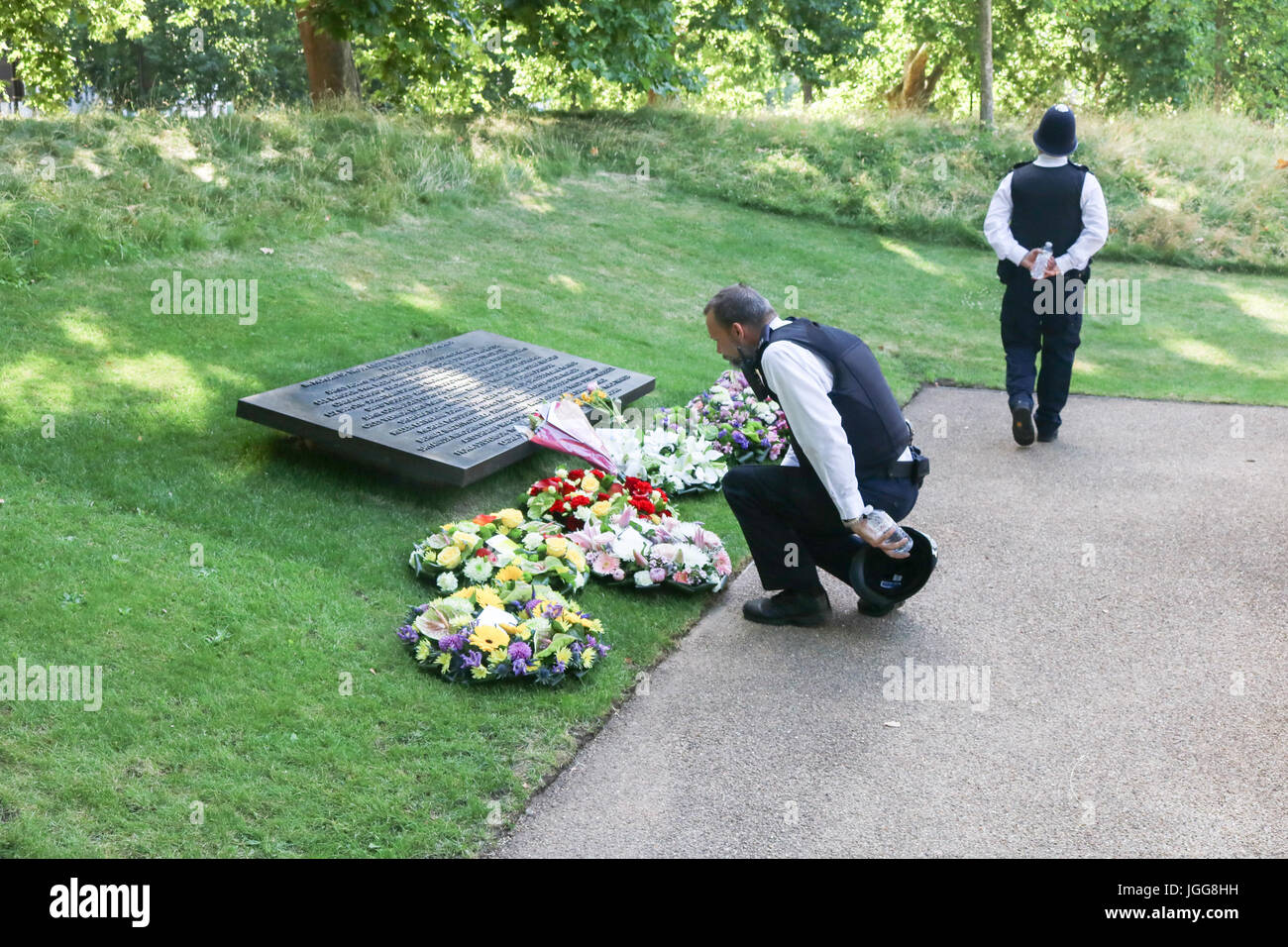 London, UK. 7th July, 2017. Police officers view the floral tributes at ...