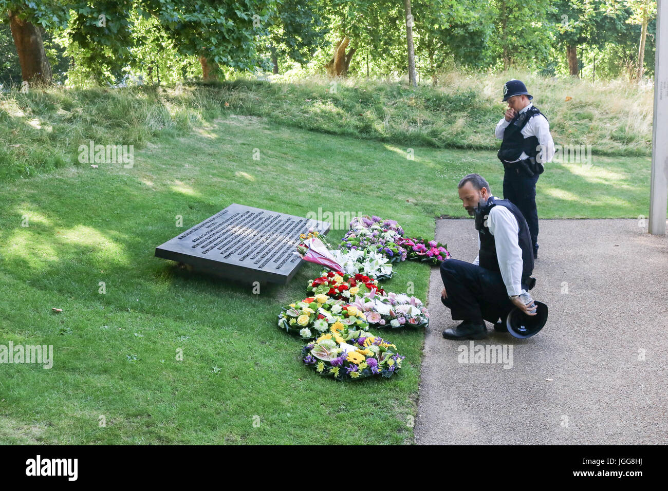 London, UK. 7th July, 2017. Police officers view the floral tributes at ...
