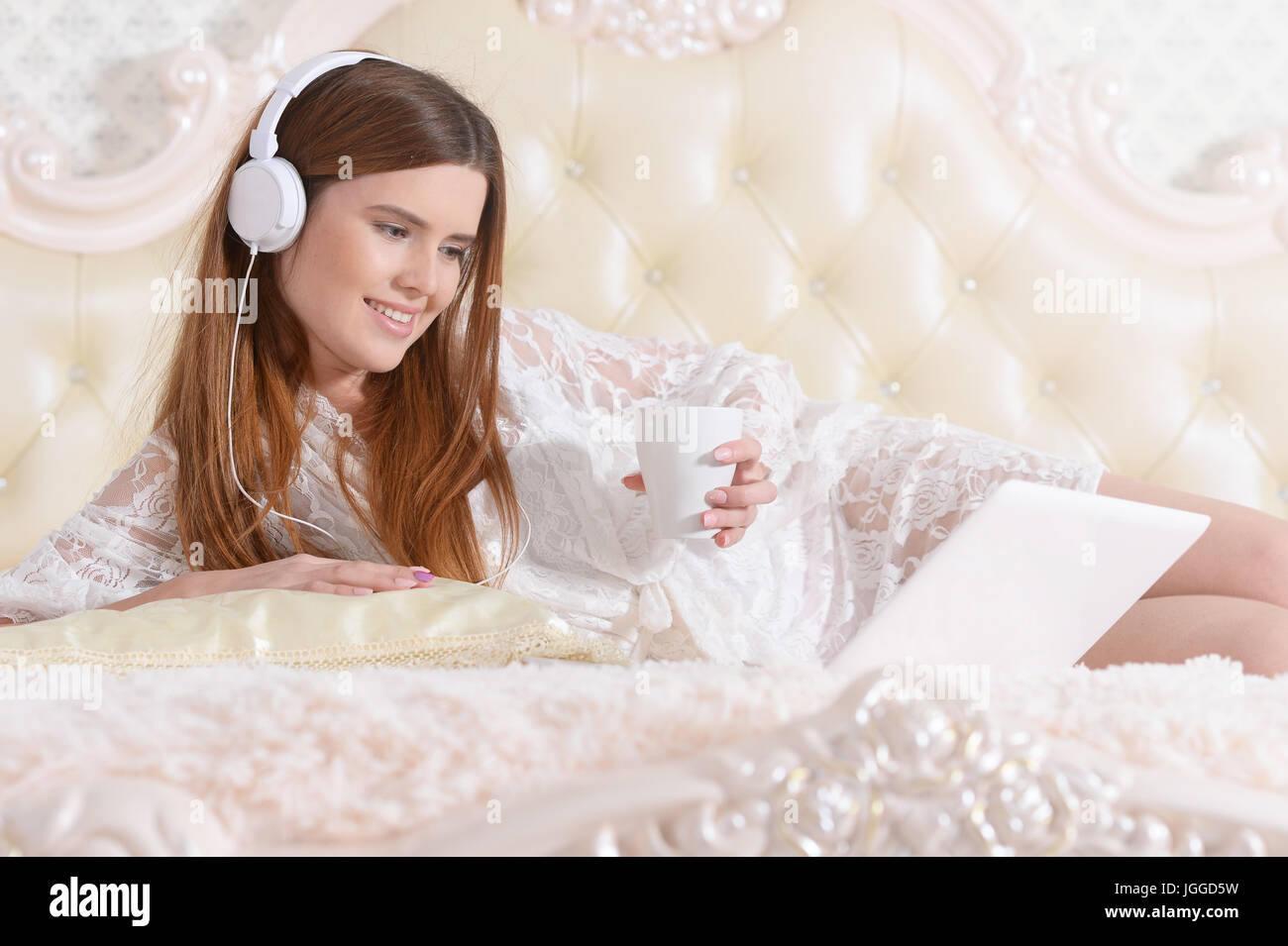 Young woman lying on bed Stock Photo - Alamy