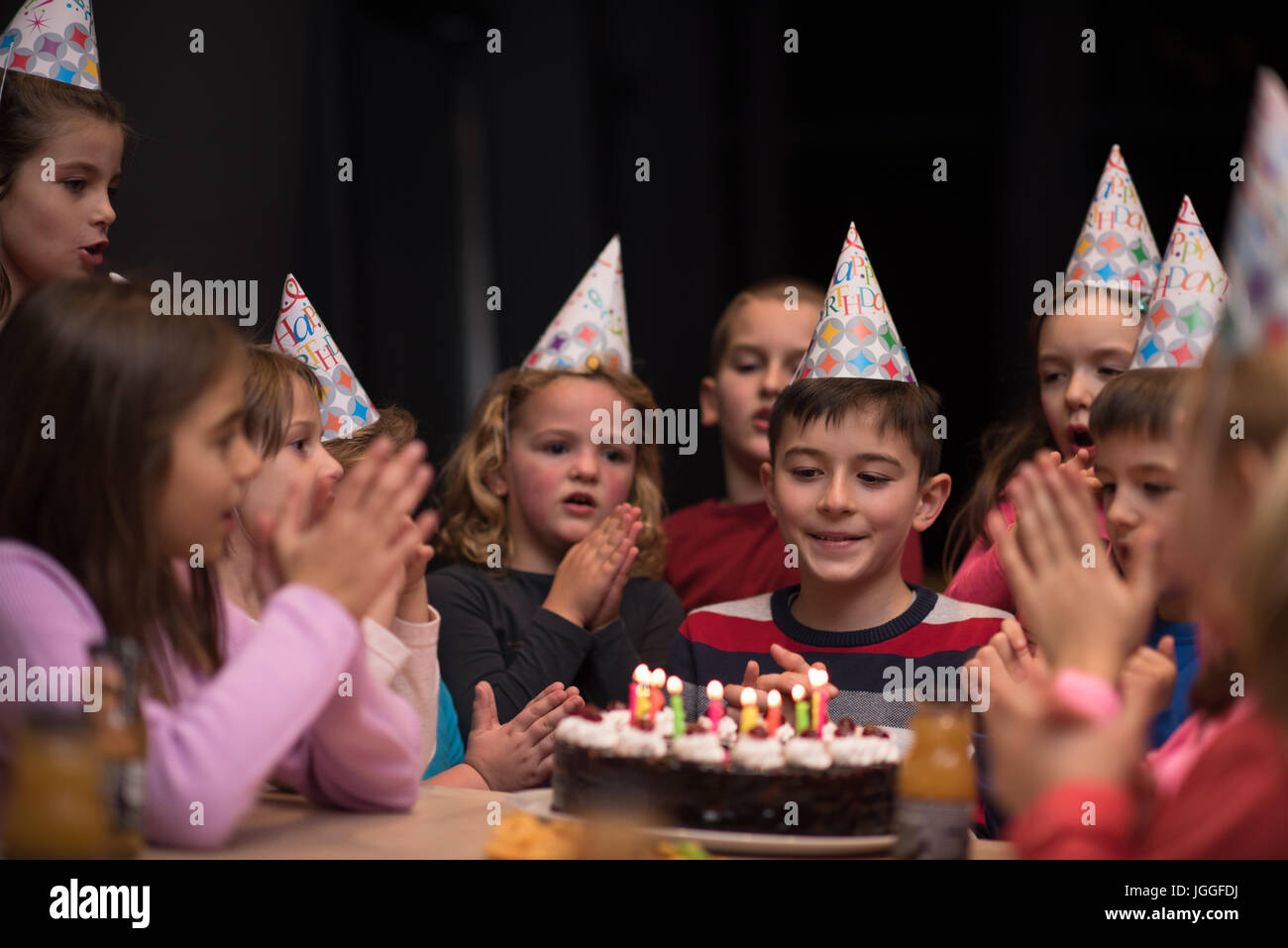 The young boy joyfully celebrating his birthday with a group of his ...