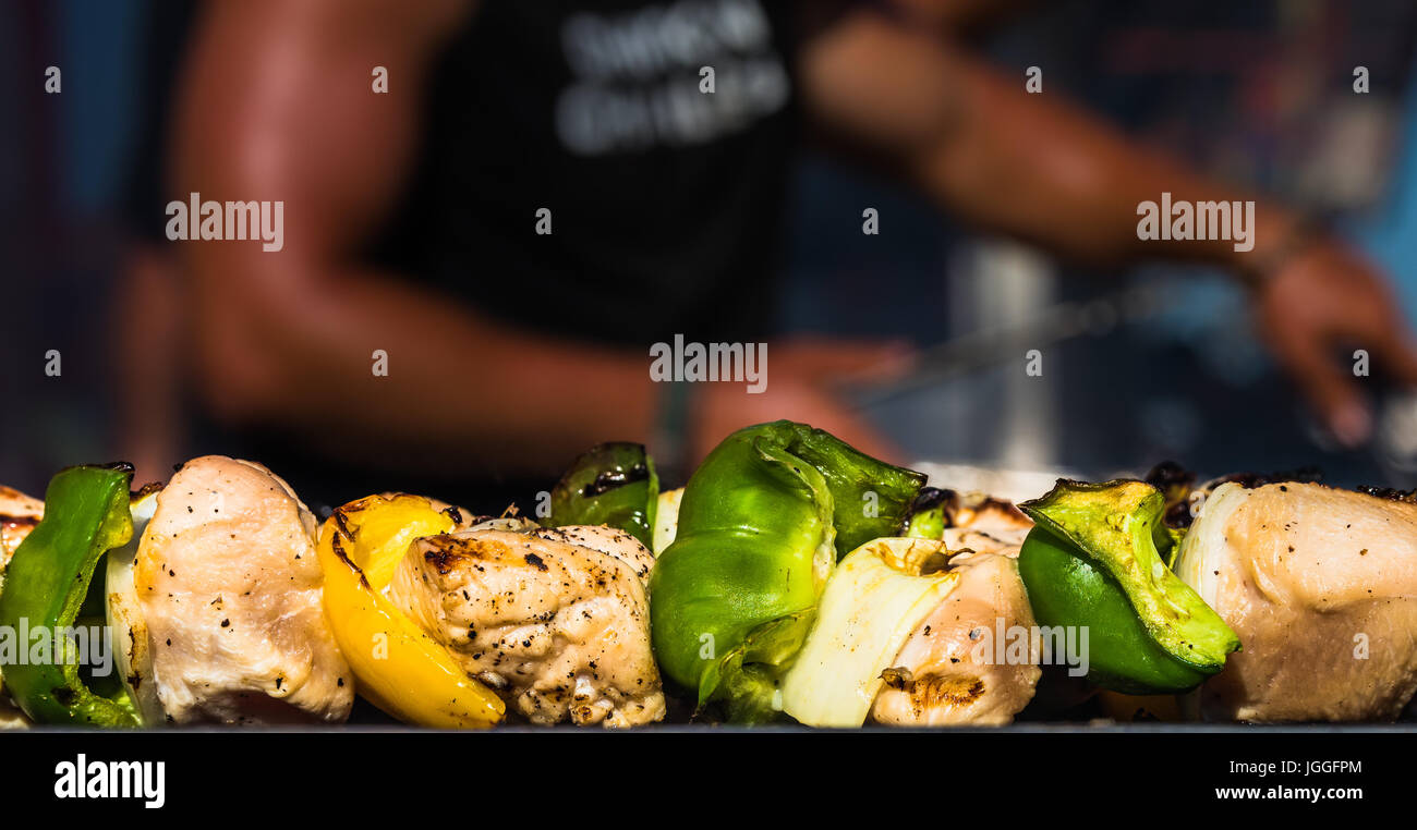 Chicken kabob with person cooking Stock Photo - Alamy