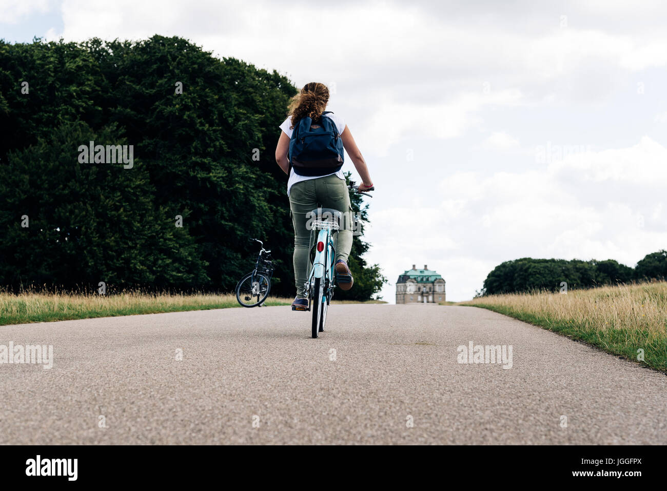 Pretty young woman riding bike in a country road in the park Stock ...