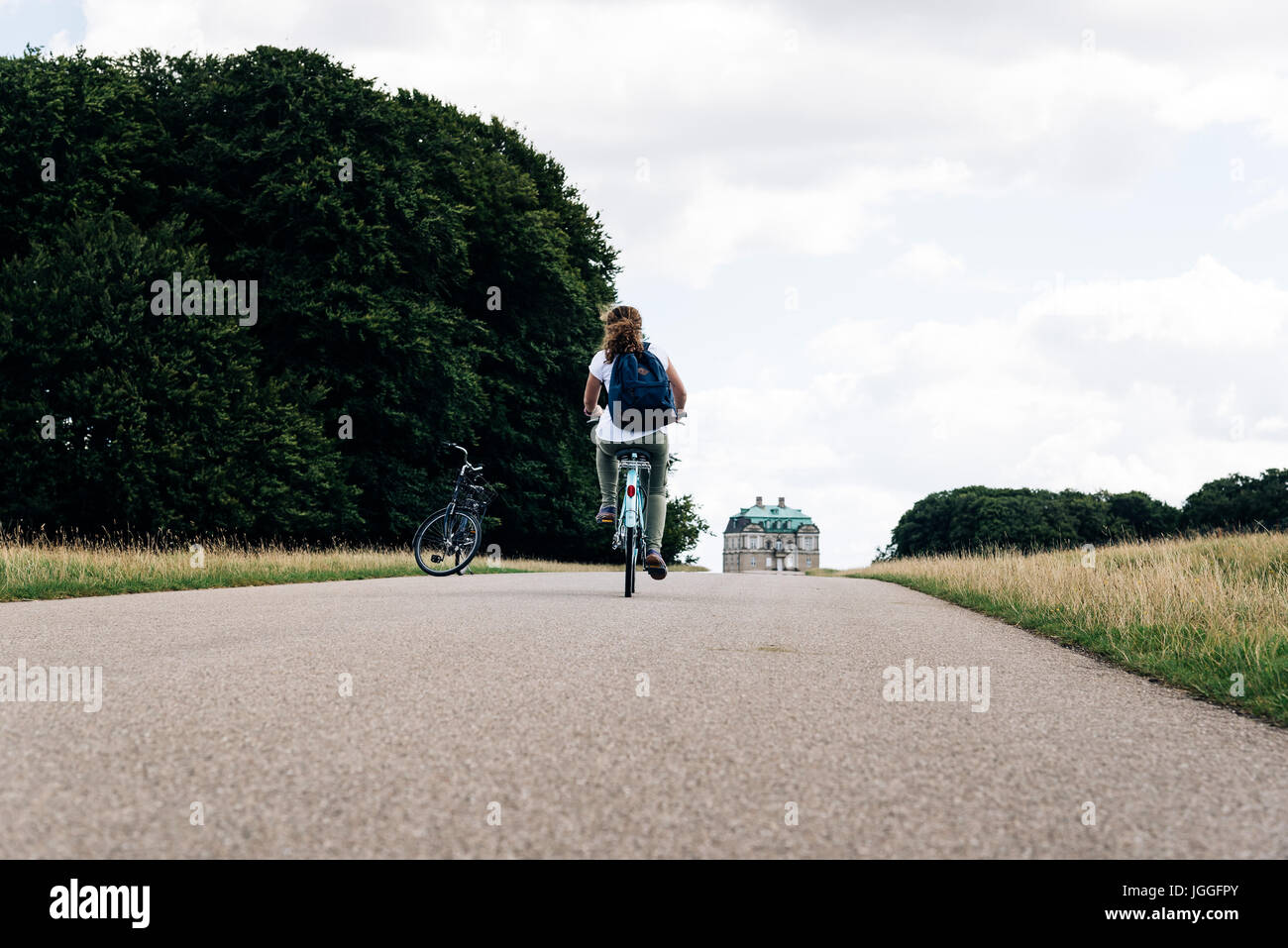 Pretty young woman riding bike in a country road in the park Stock ...