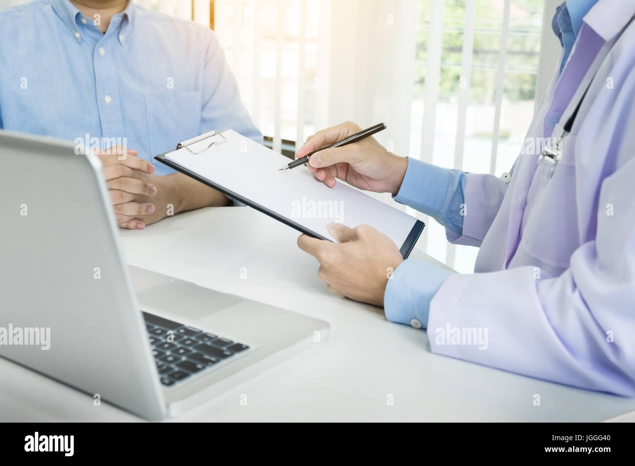 patient listening intently to a male doctor explaining patient symptoms ...
