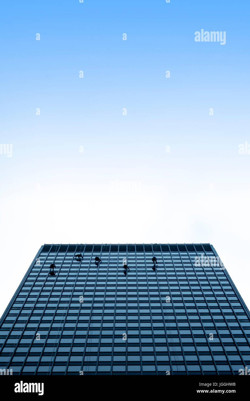 Window cleaners cleaning windows of modern office tower high rise ...