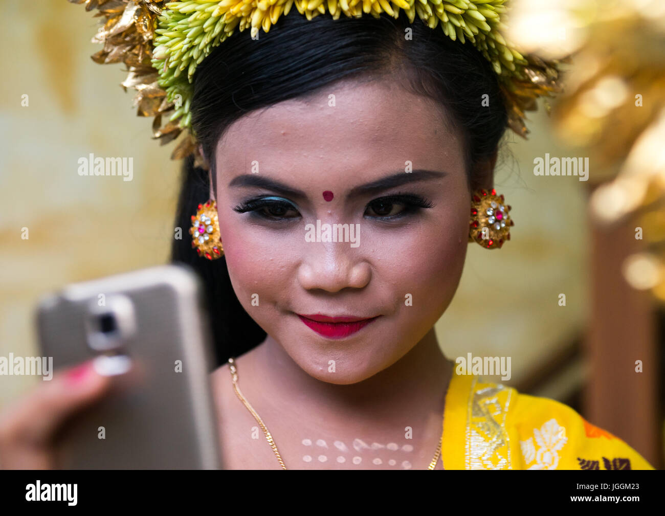 A teenage girl in traditional costume making a selfie before a tooth ...