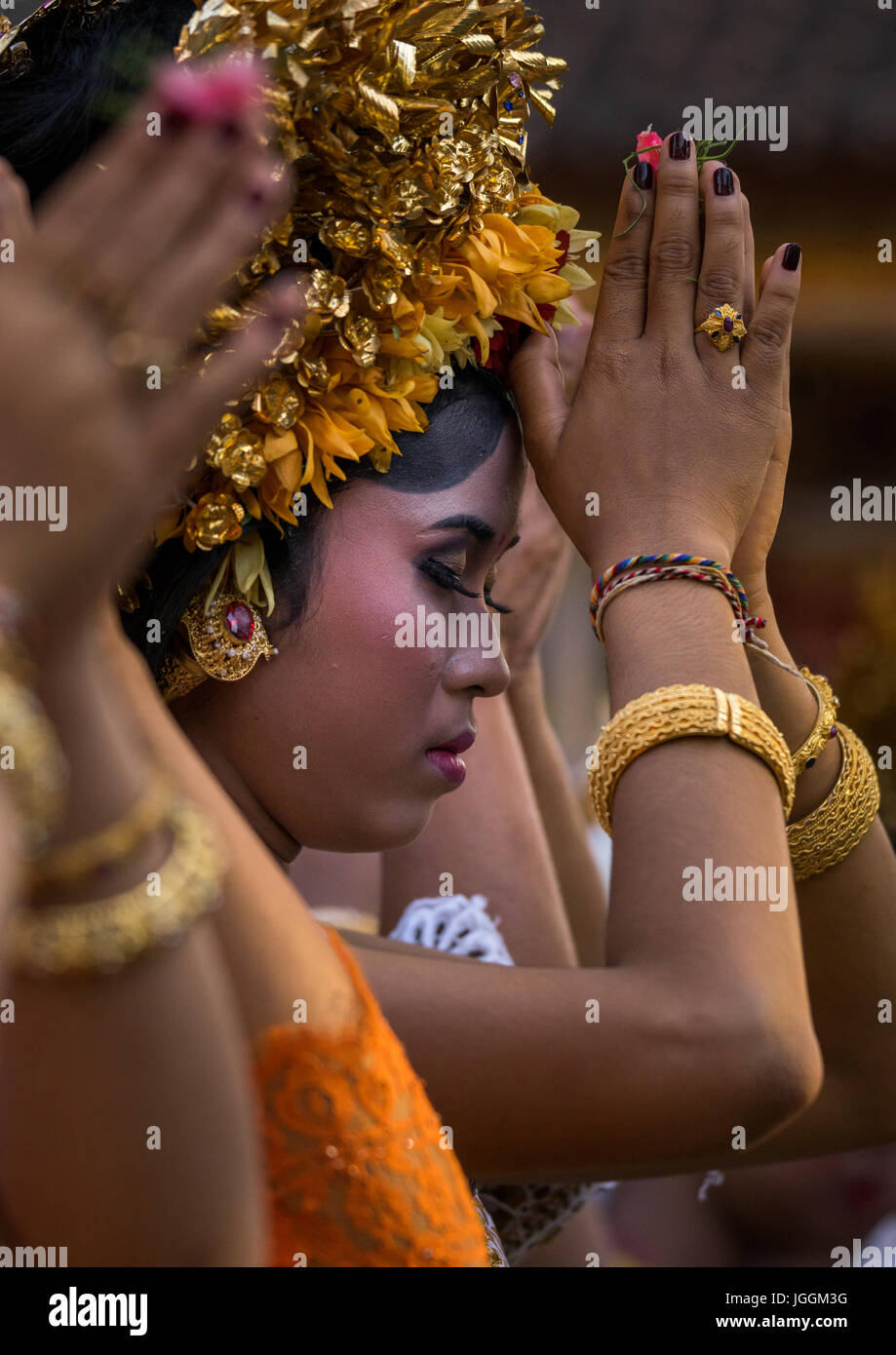 Teenage girls in traditional costume praying before a tooth filing ...