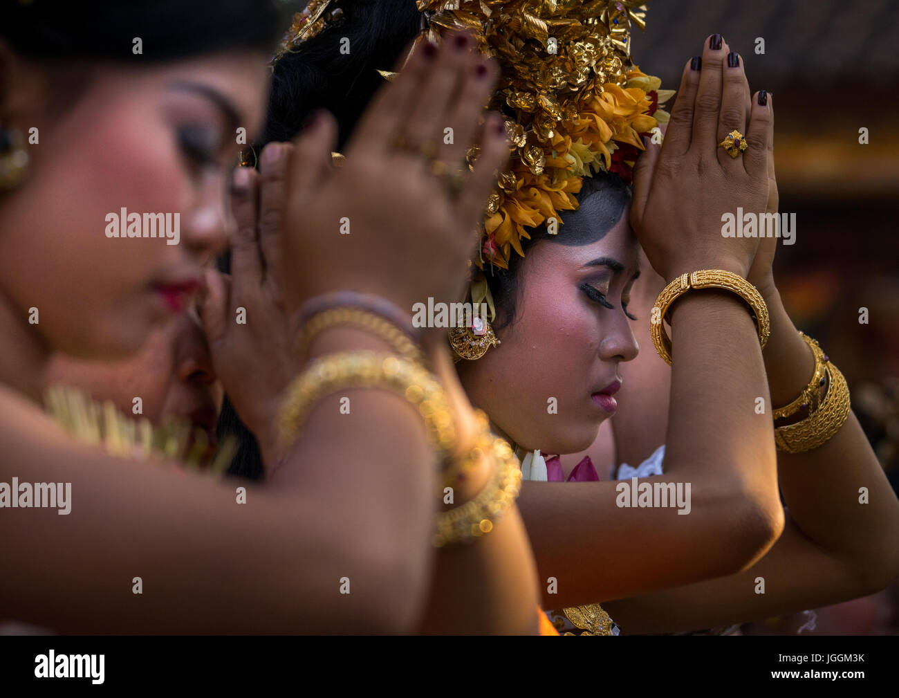 Teenage girls in traditional costume praying before a tooth filing ...