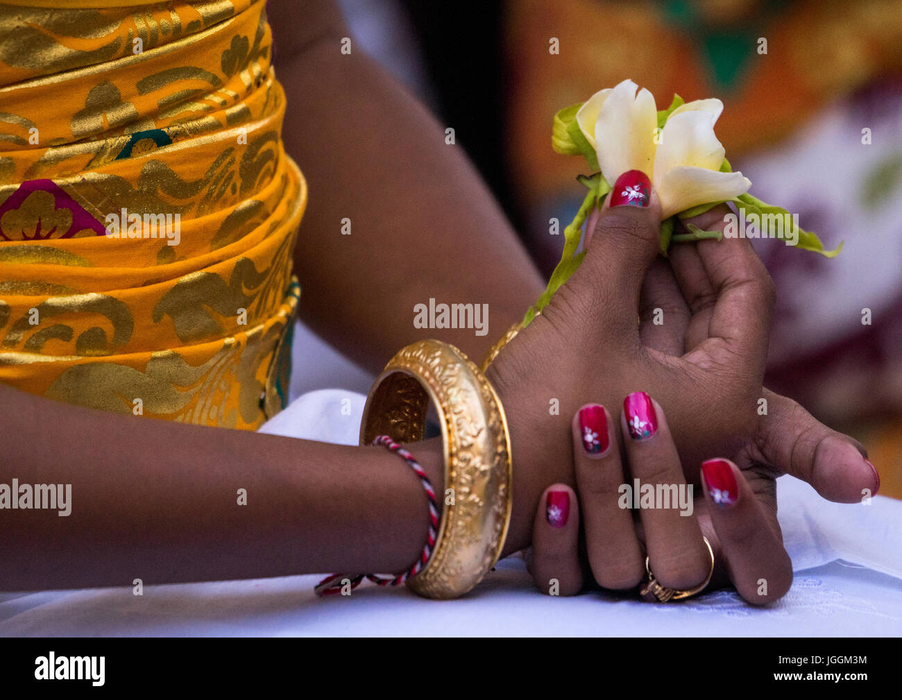 A teenage girl with flowers in the hand before a tooth filing ceremony ...