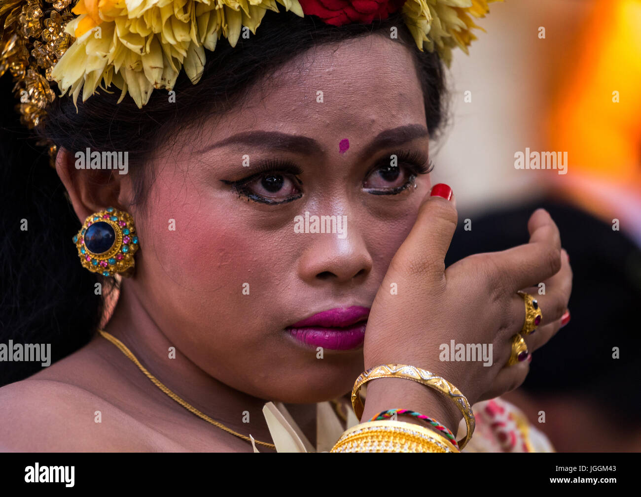 A teenager girl in traditional costume crying before a tooth filing ...