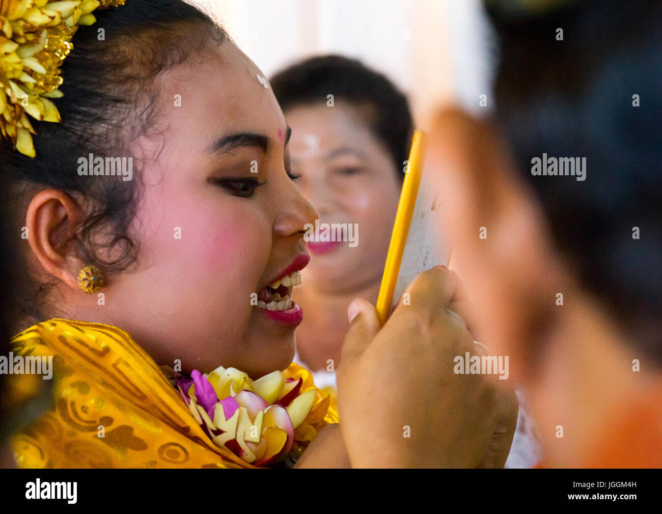 Teenage girl looking at her new teeth in a mirror during the the tooth ...