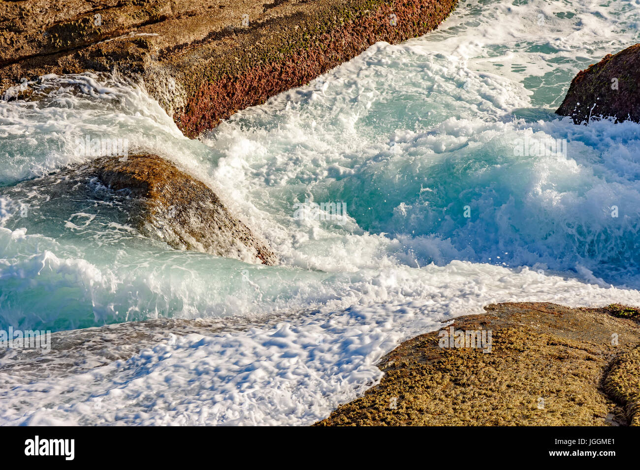 Sea water splashing over the stones on the beach Stock Photo - Alamy