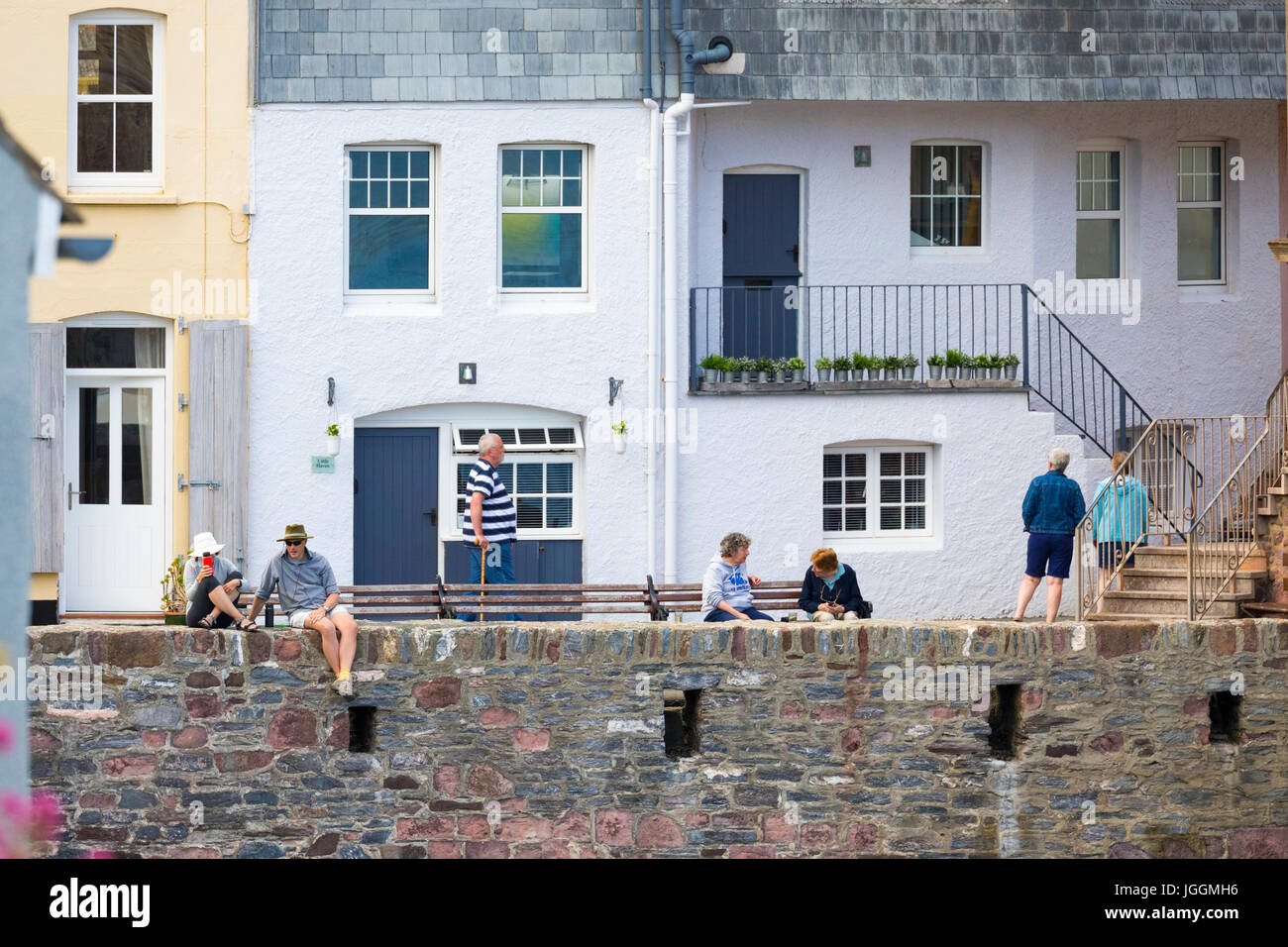 People relaxing at a harbour at the quaint English seaside village of ...
