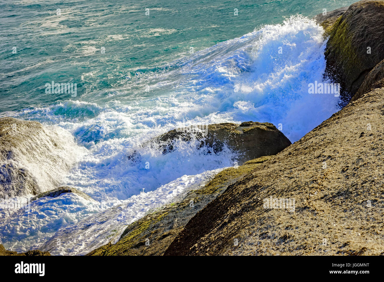 Sea water splashing over the stones on the beach Stock Photo - Alamy