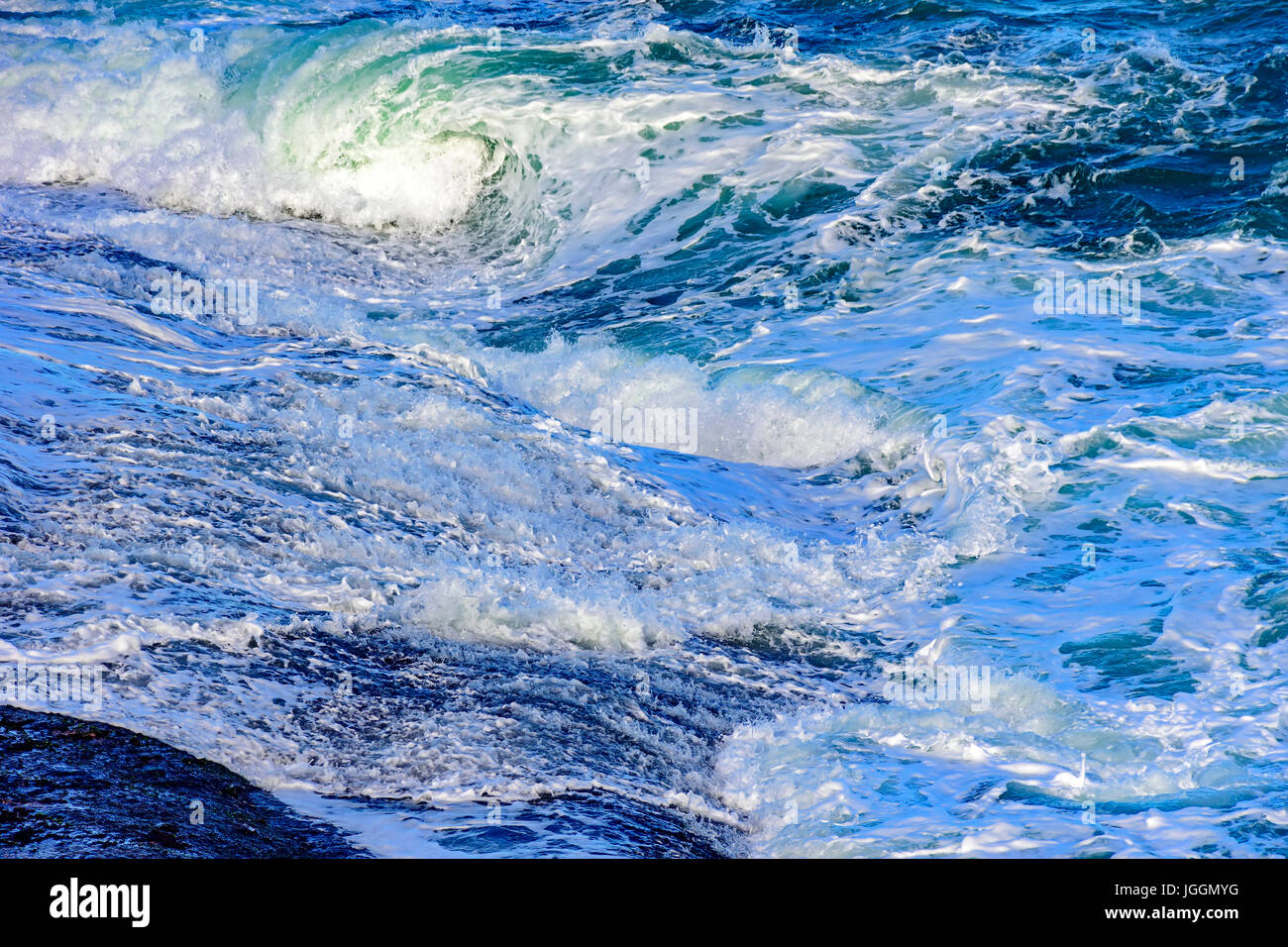 Sea water breaking over the stones on the beach Stock Photo - Alamy