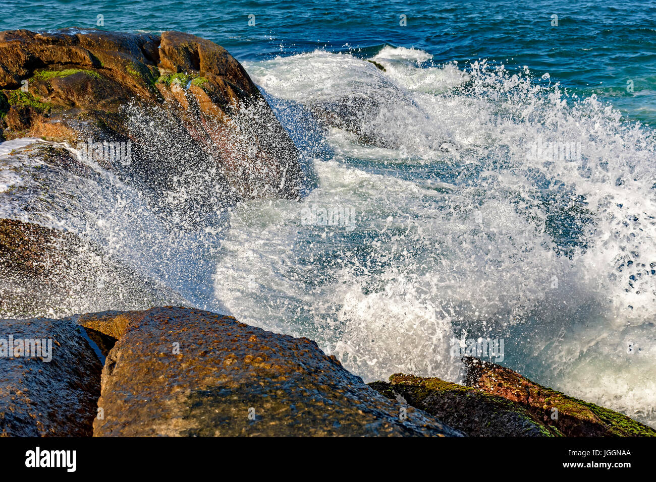 Sea water spray over the stones on the beach Stock Photo - Alamy