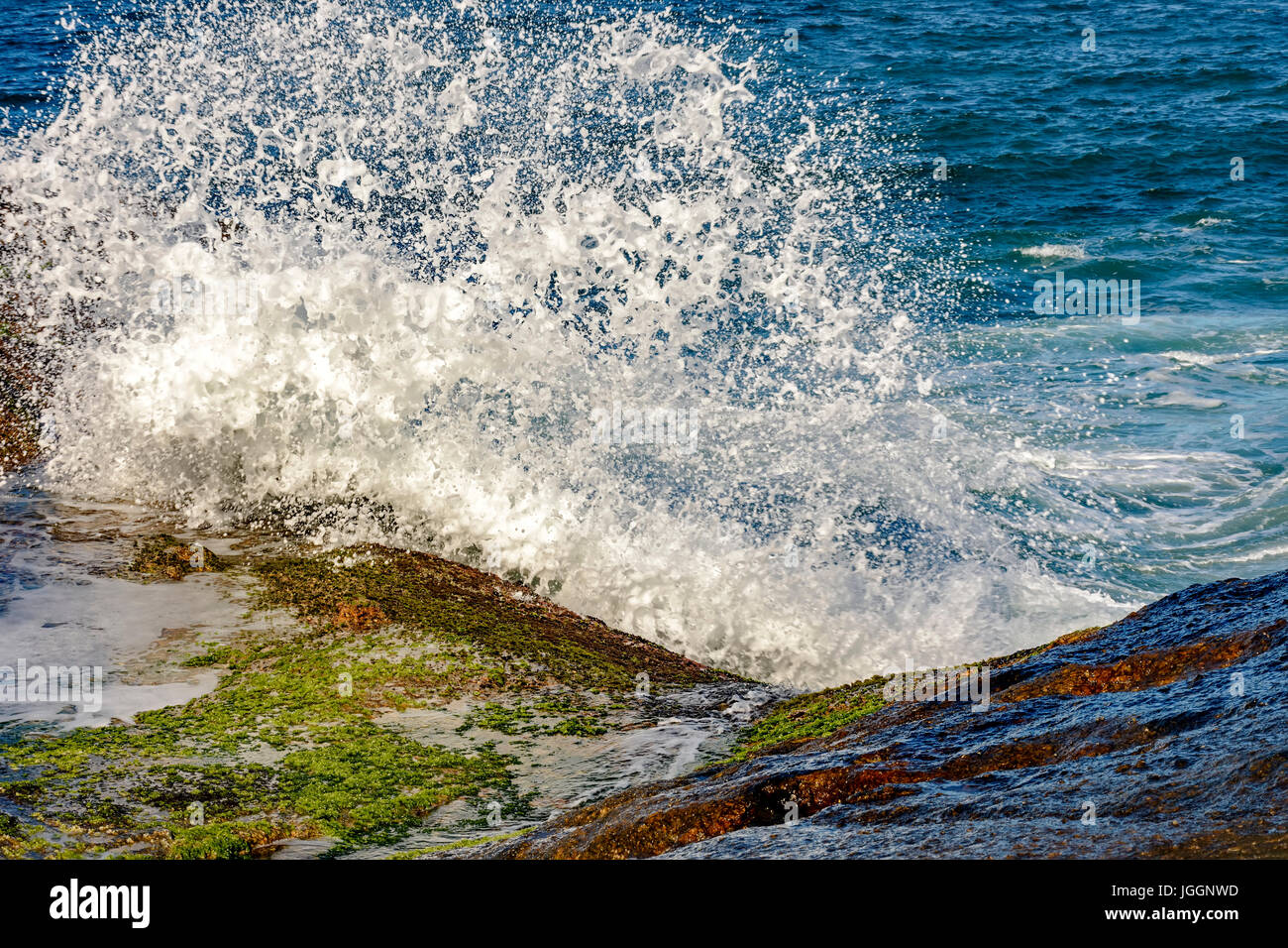 Sea water splashing over the stones on the beach Stock Photo - Alamy