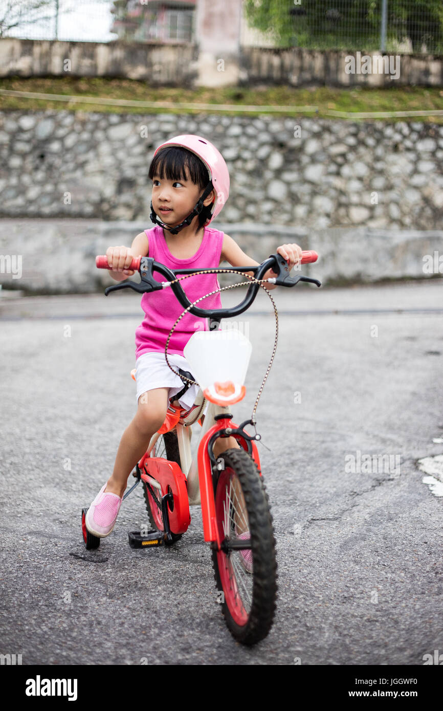 Asian Chinese little girl riding bicycle on tar road outdoor Stock ...