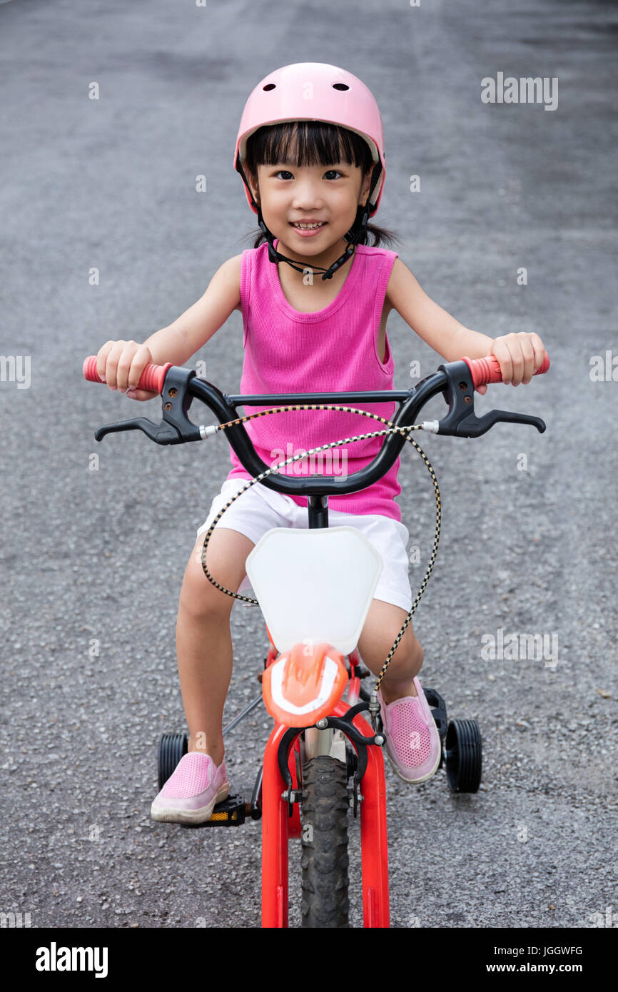 Asian Chinese little girl riding bicycle on tar road outdoor Stock ...