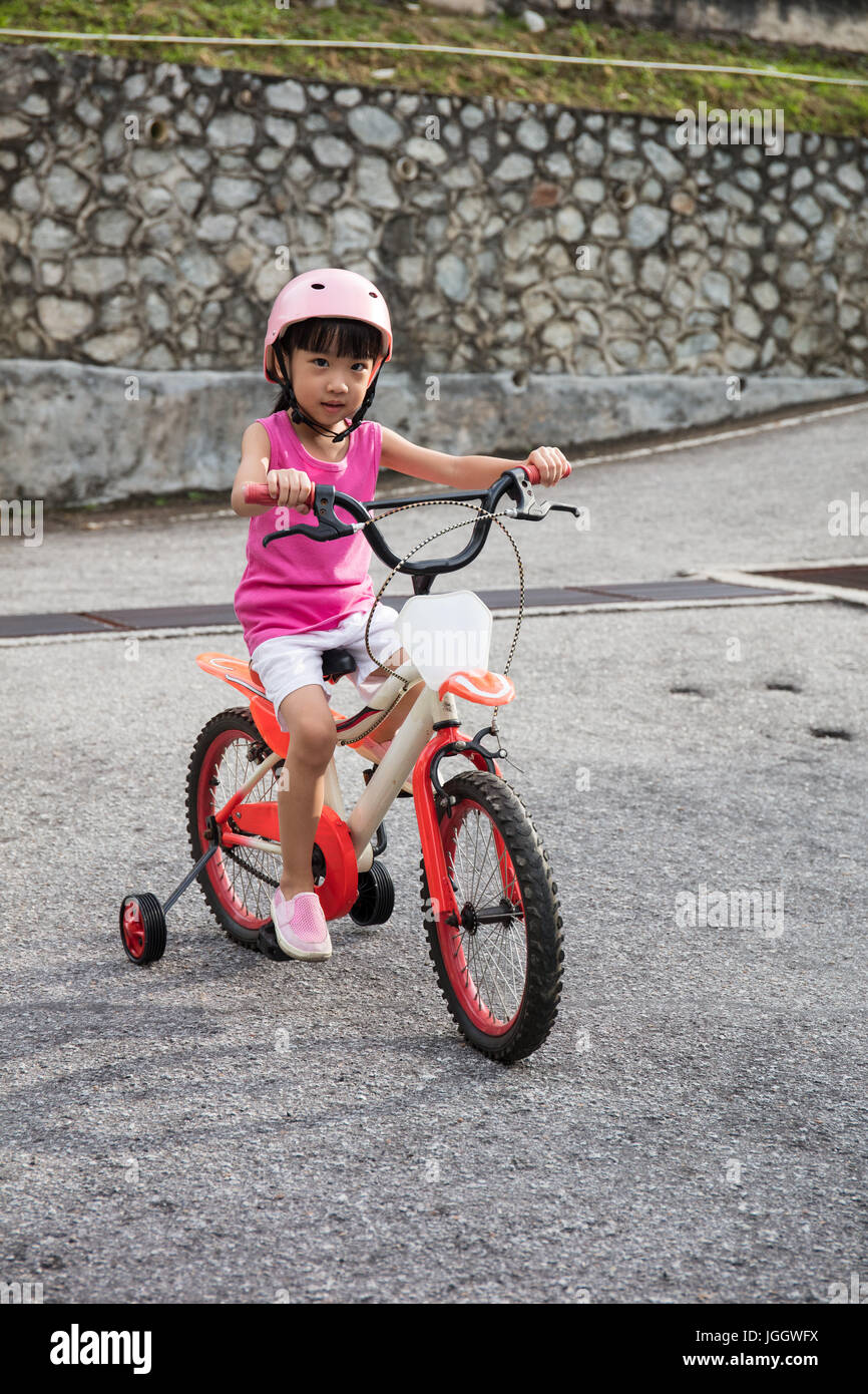Asian Chinese little girl riding bicycle on tar road outdoor Stock ...