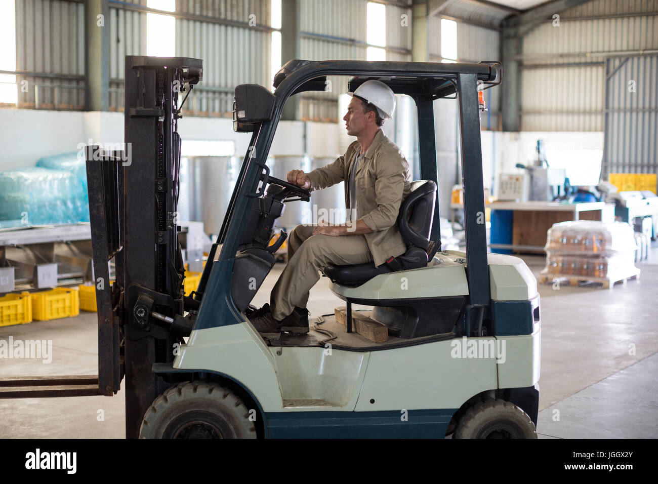 Worker driving forklift in oil factory Stock Photo - Alamy