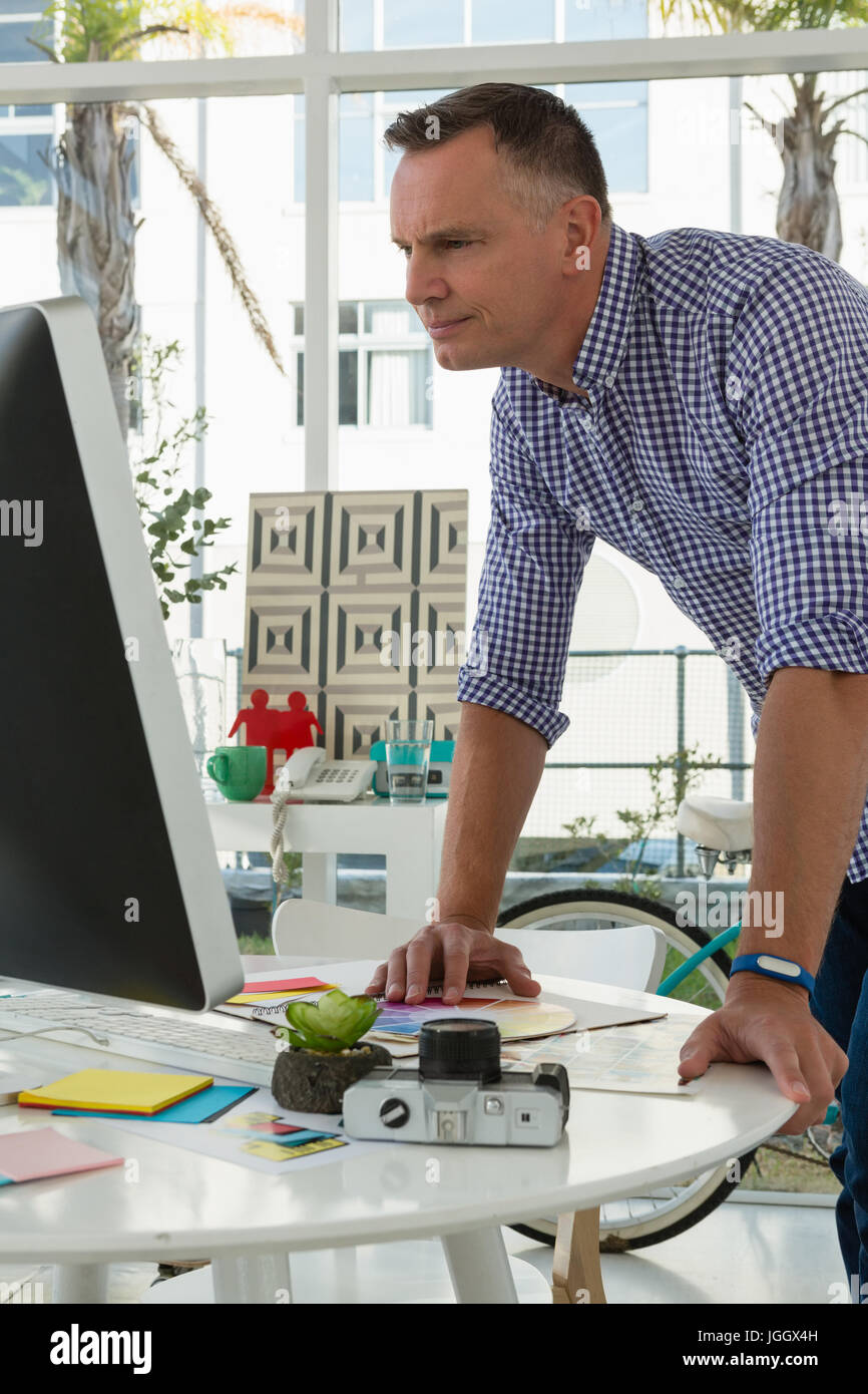 Designer using computer while standing at studio Stock Photo - Alamy