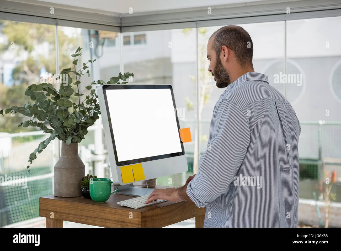 Side view of designer using computer while standing in studio Stock ...
