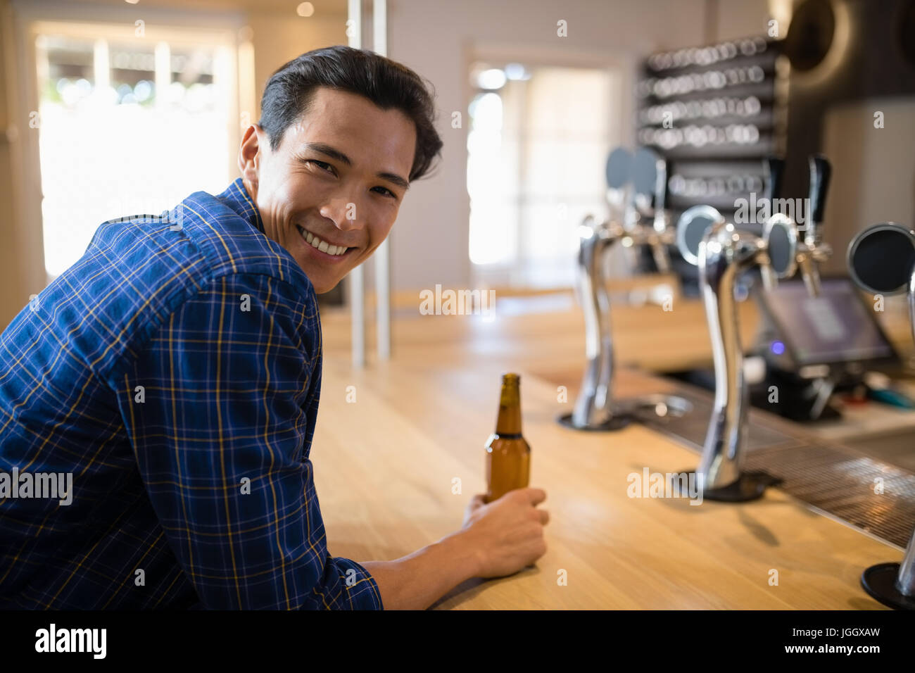 Man having beer at counter in bar Stock Photo - Alamy