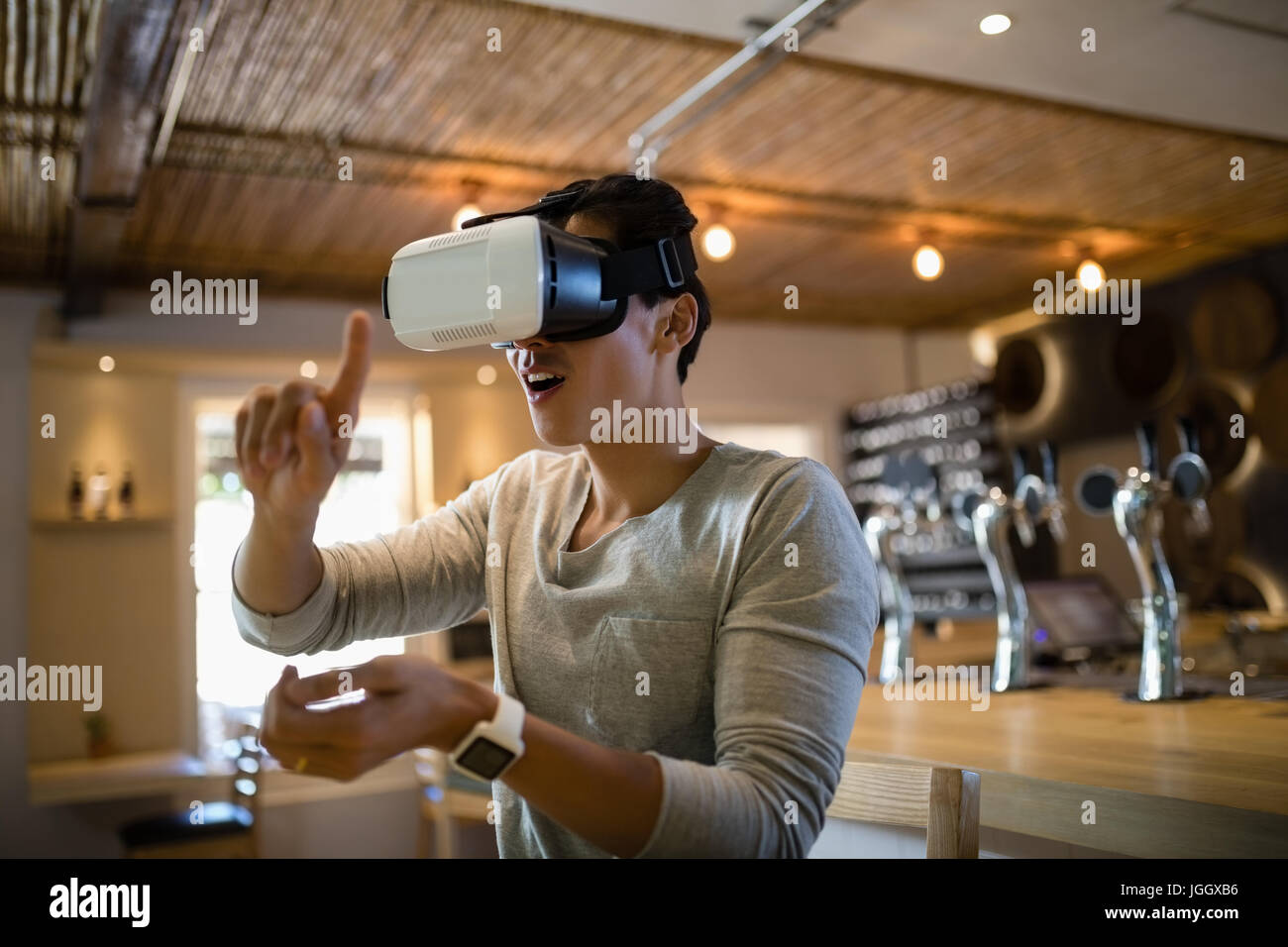 Smiling man using virtual reality headset in restaurant Stock Photo - Alamy