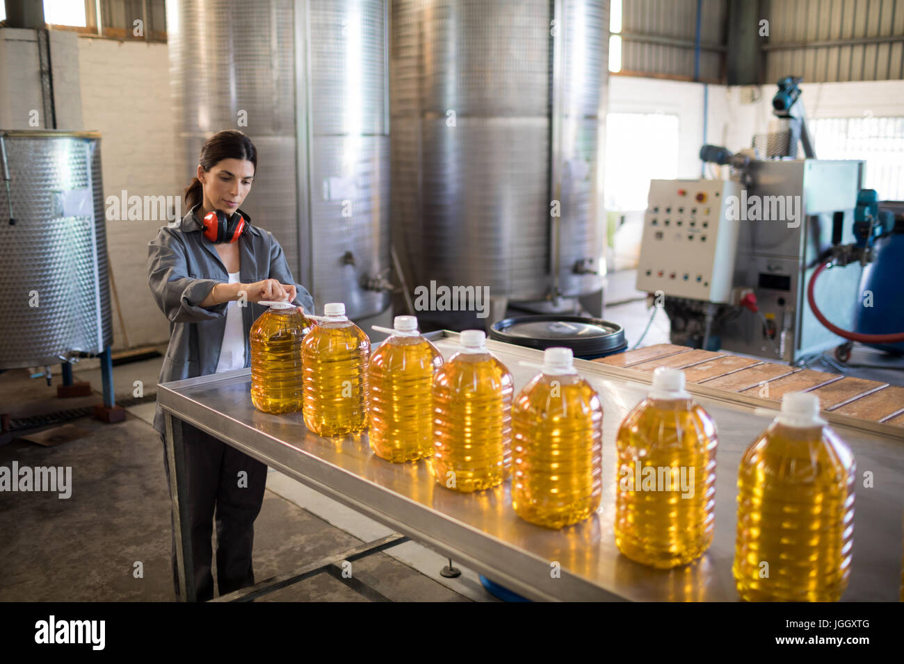 Attentive female worker working in oil factory Stock Photo - Alamy