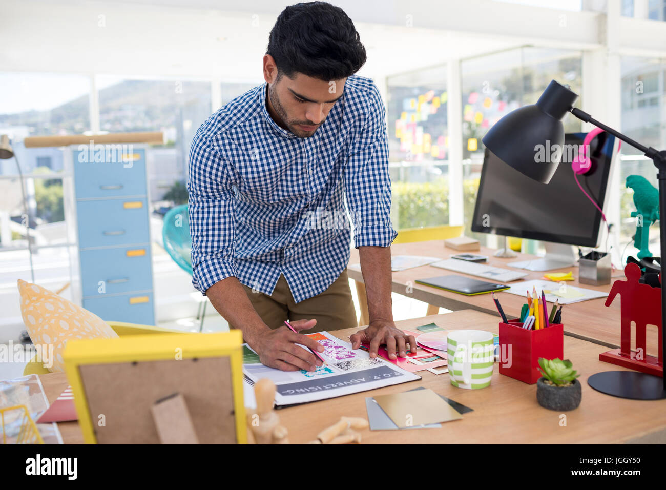 Male graphic designer working at desk in the office Stock Photo - Alamy