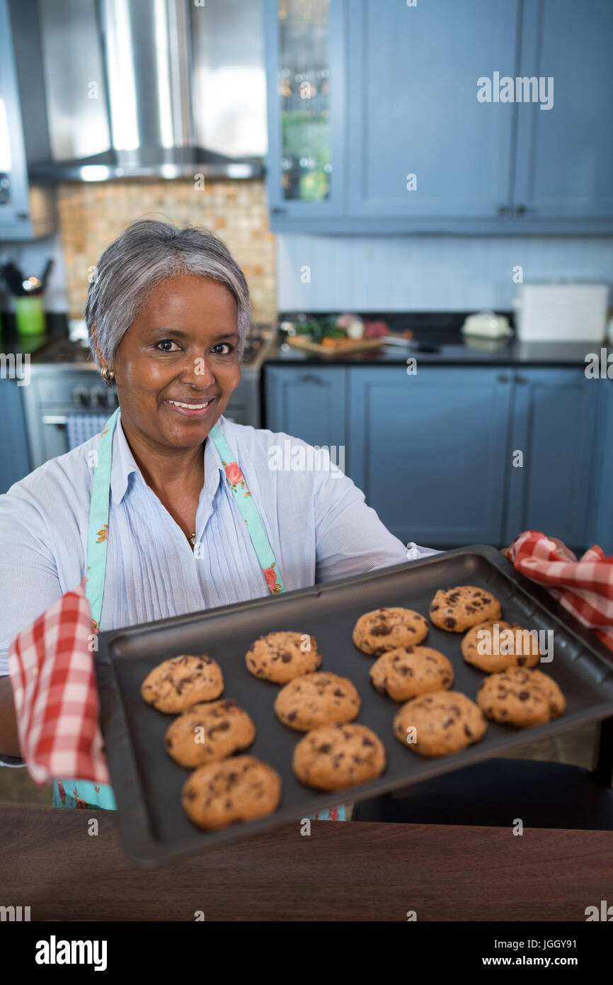 High angle portrait of woman showing baked cookies while standing in ...
