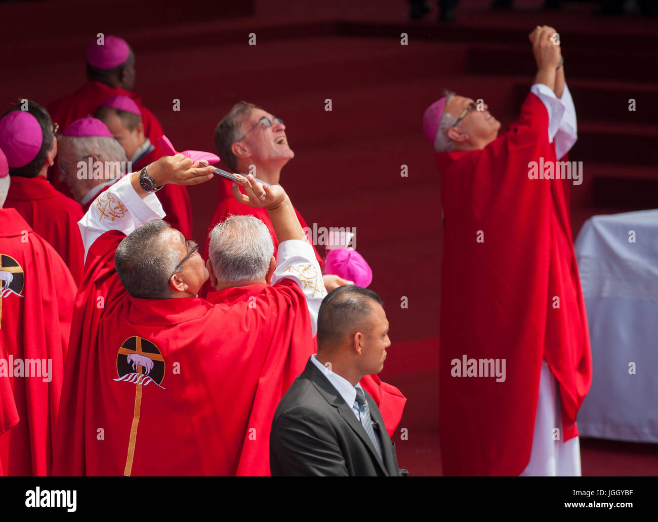 Flanked by a Salvadoran presidential security agent, priests turn their ...