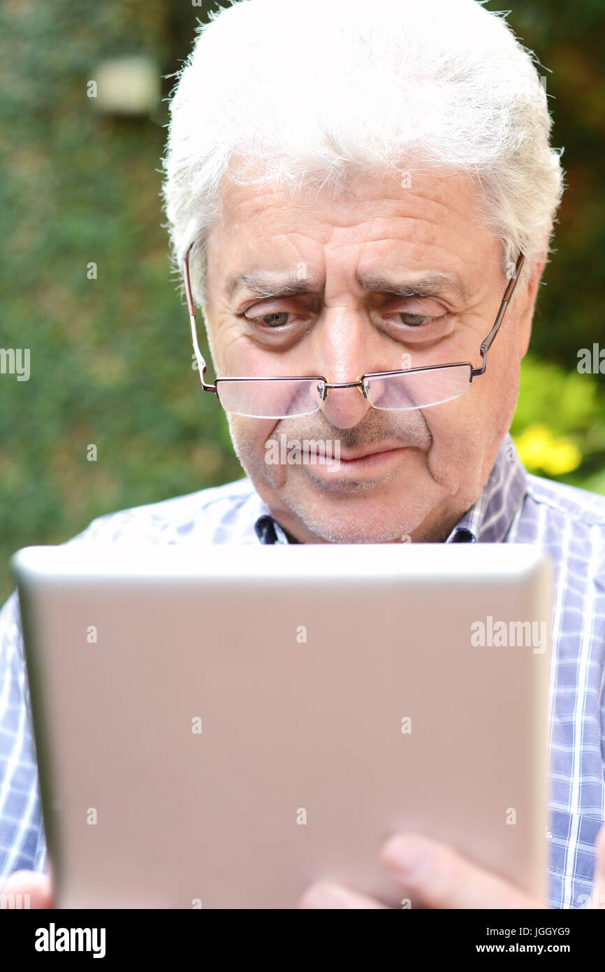 Portrait of an old man using digital tablet. Outdoors Stock Photo - Alamy