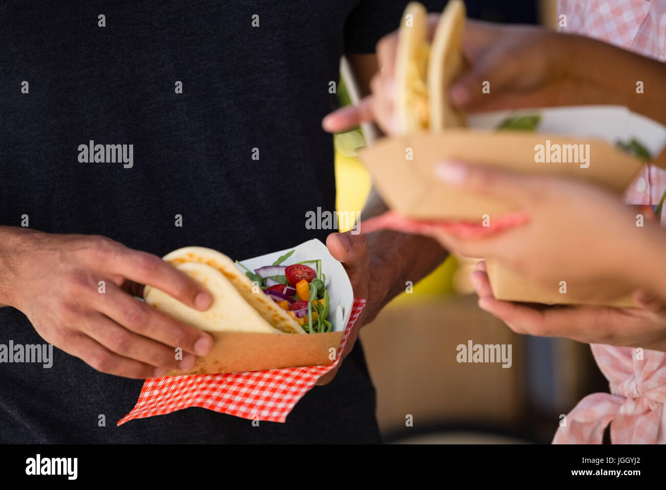 Cropped hands of friends holding tortilla Stock Photo - Alamy