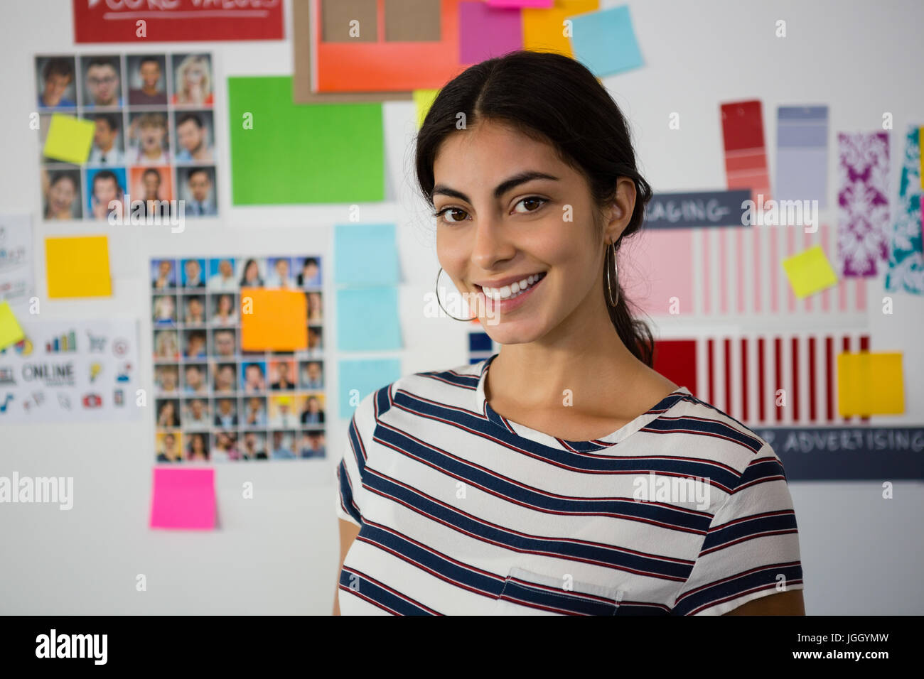 Portrait of beautiful woman standing against sticky notes in creative ...