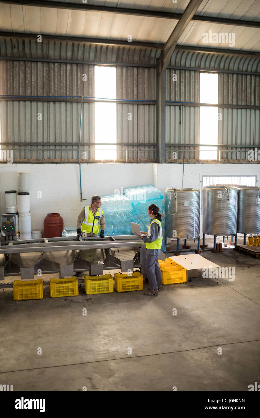 Workers working together near production line in oil factory Stock ...