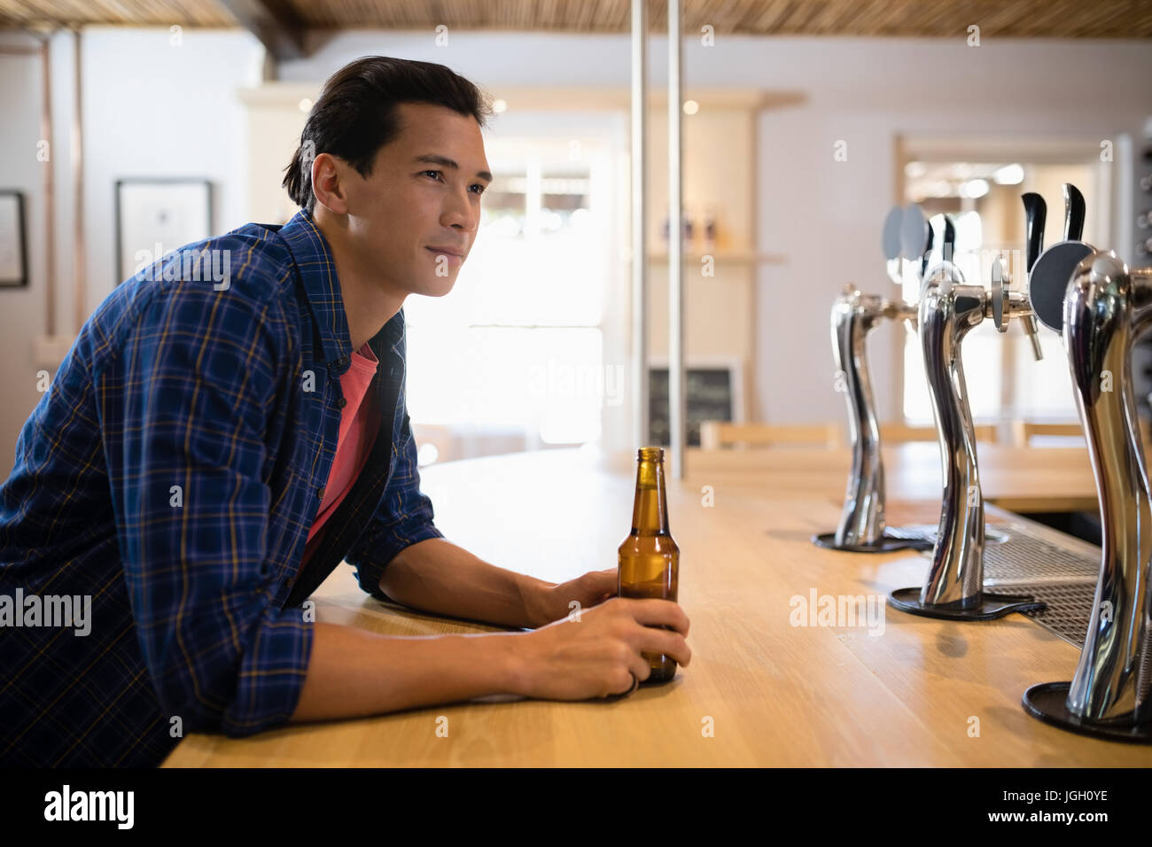 Man having beer at counter in bar Stock Photo - Alamy