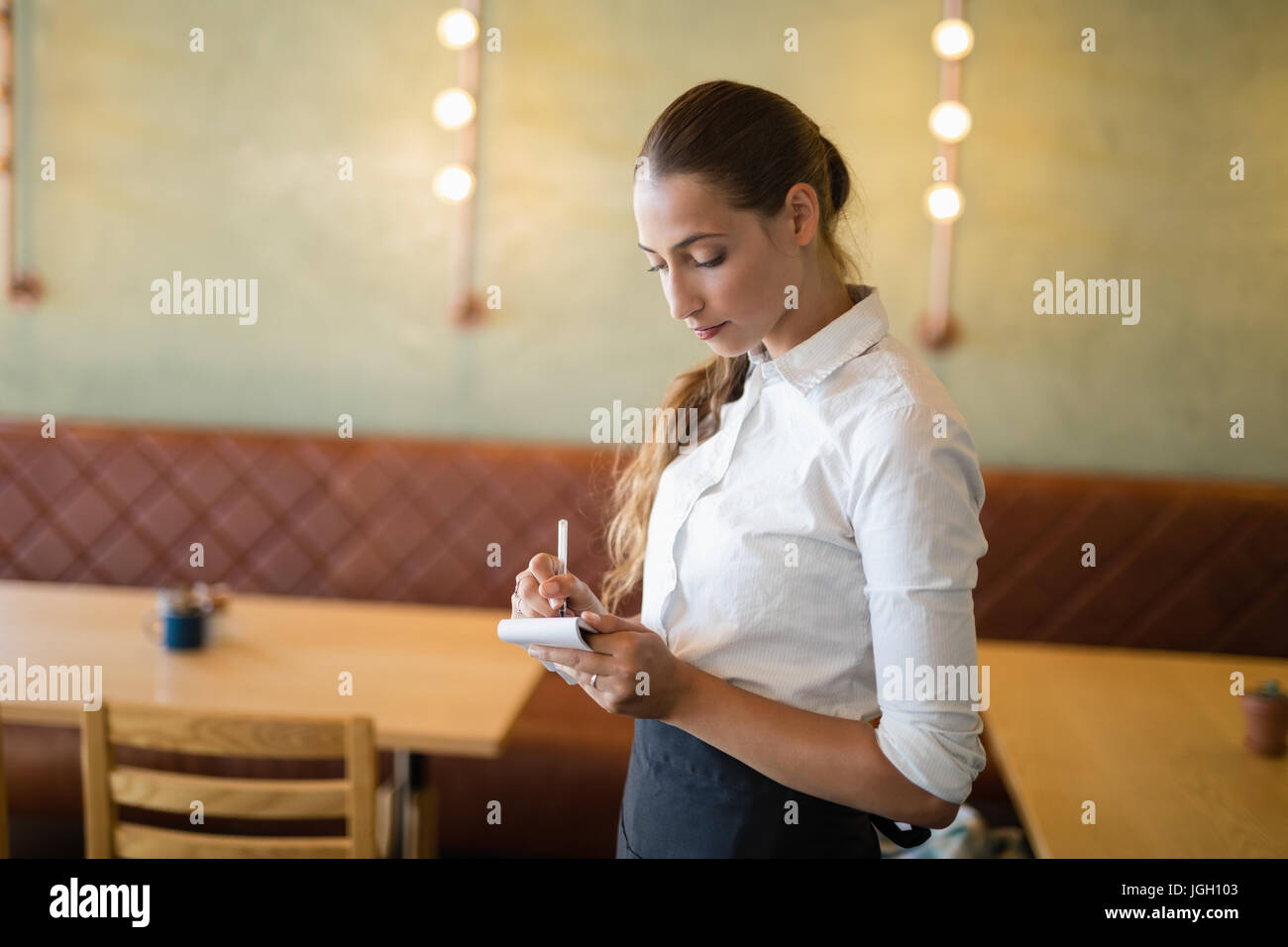 Waitress taking an order on notepad in bar Stock Photo - Alamy