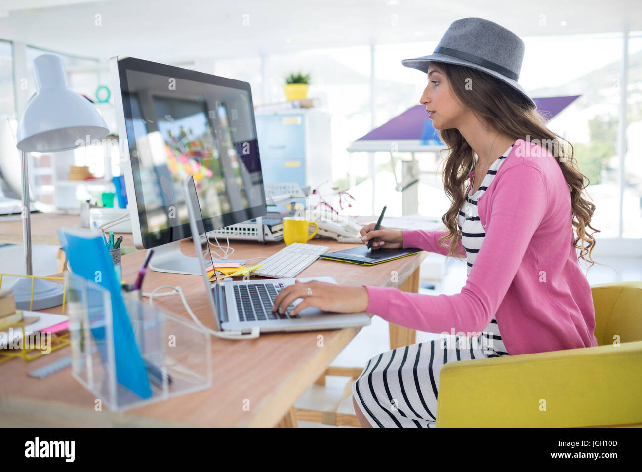 Female graphic designer working at desk in the office Stock Photo - Alamy