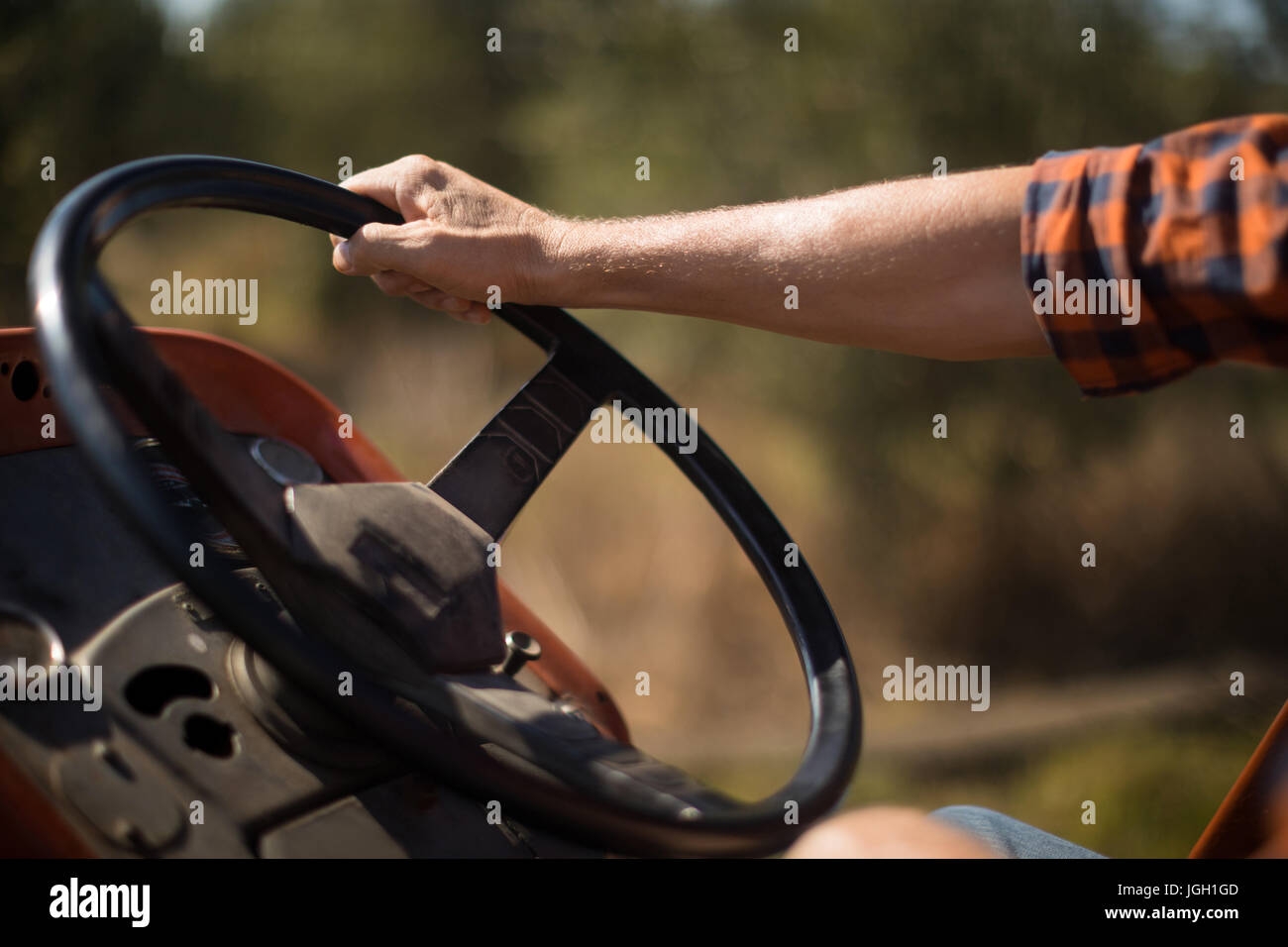 Close-up of man driving tractor in olive farm on a sunny day Stock ...