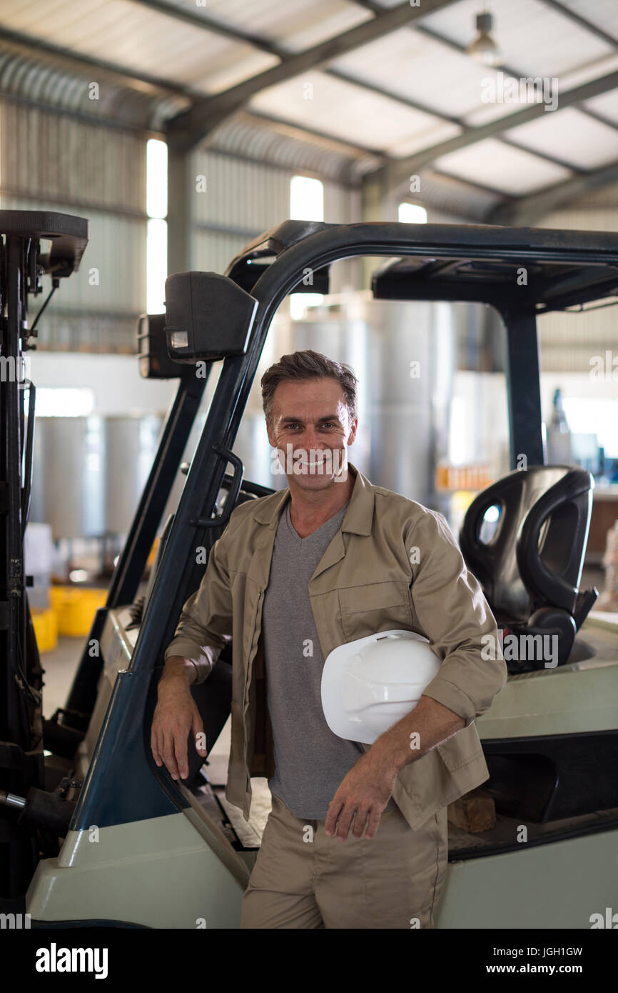 Portrait of happy worker standing near forklift in oil factory Stock ...
