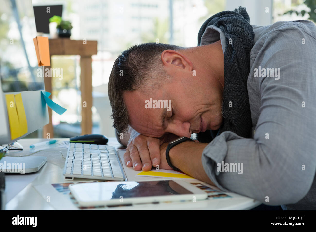 Businessman sleeping while sitting at desk in office Stock Photo - Alamy