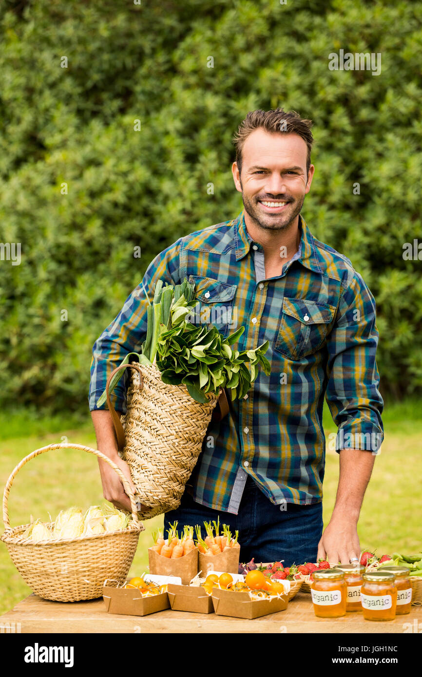 Portrait of smiling handsome man selling organic vegetables while ...